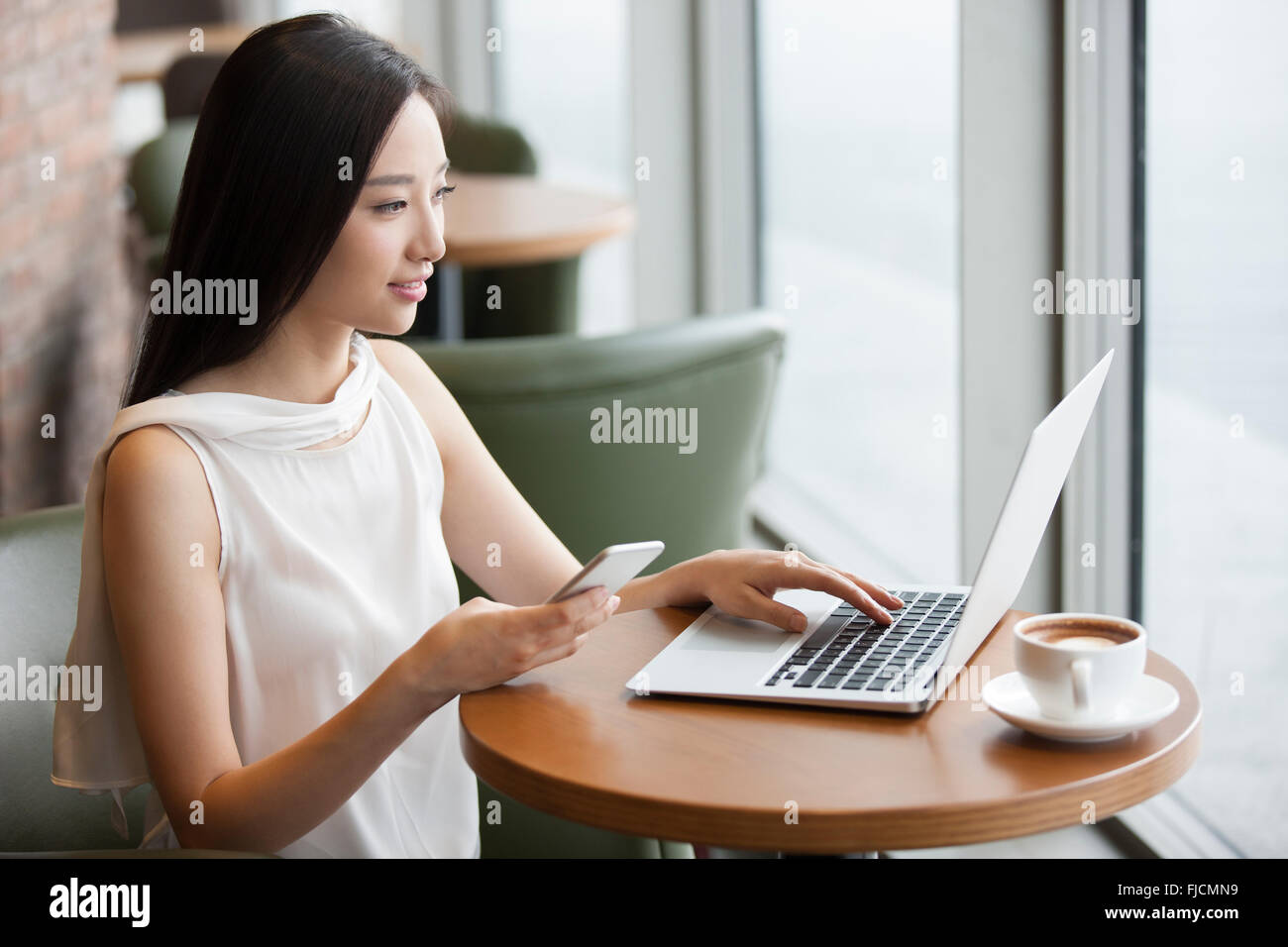 Young Chinese woman working with laptop in café Stock Photo - Alamy