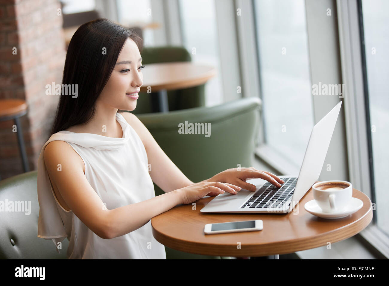 Young Chinese woman working with laptop in café Stock Photo - Alamy