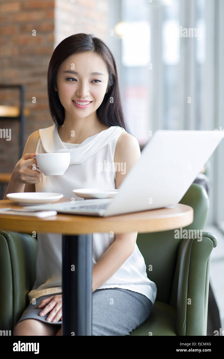 Young Chinese woman working with laptop in café Stock Photo - Alamy