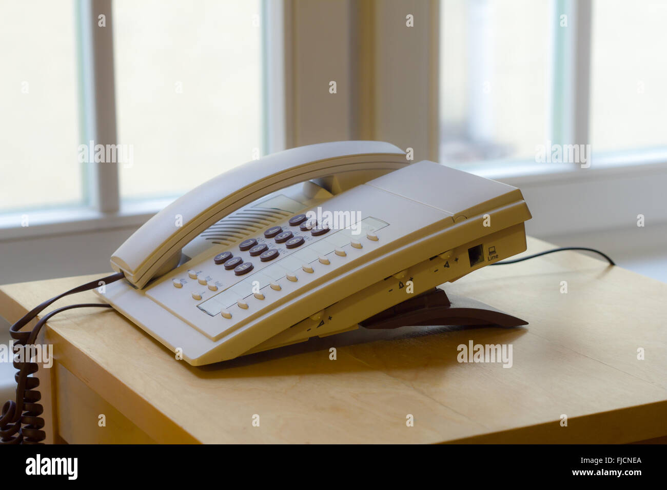 White Telephone in an office window in bright light Stock Photo - Alamy