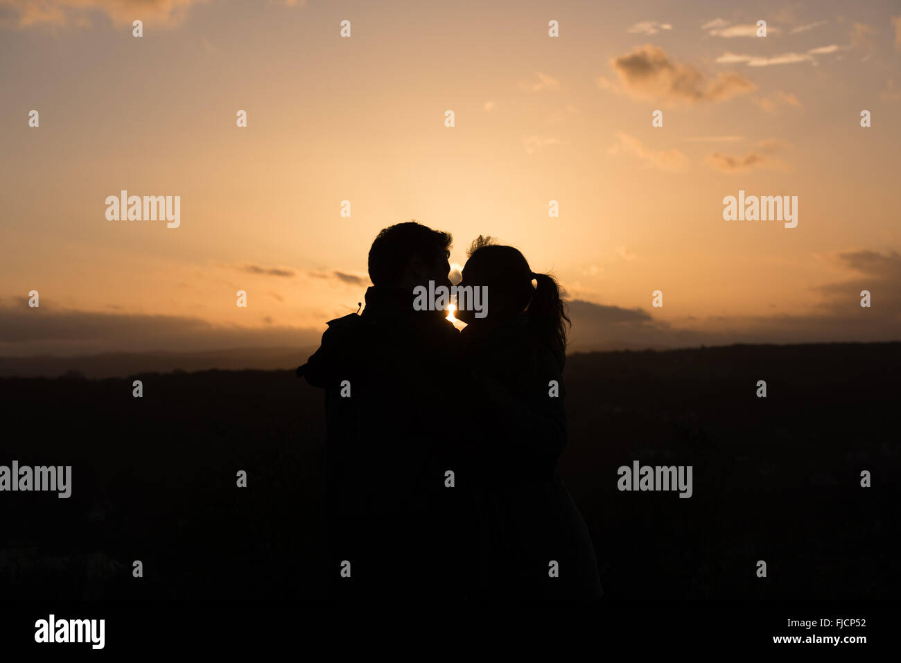 Couple kissing at sunset hi-res stock photography and images - Alamy