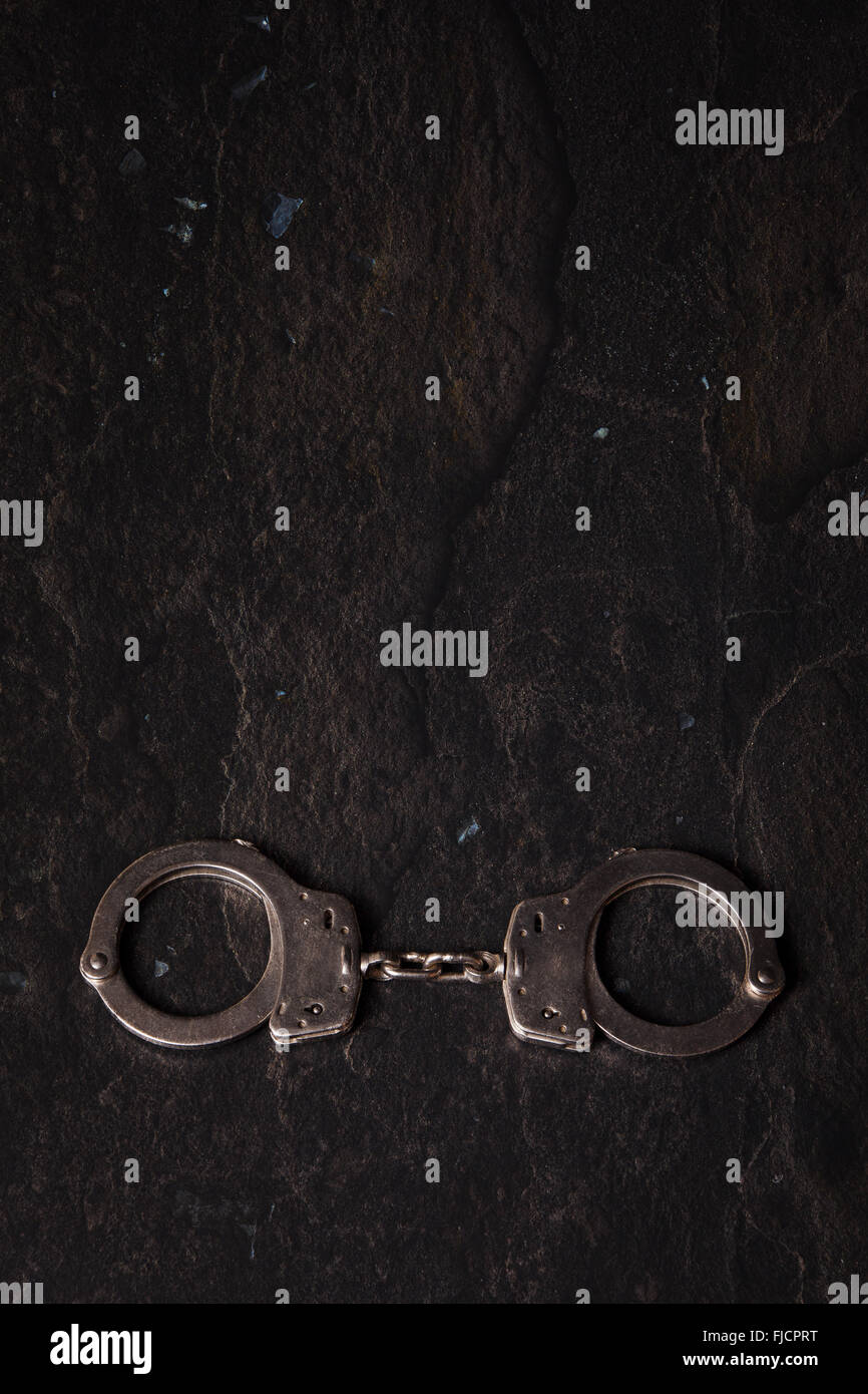 Handcuffs on a black background Stock Photo - Alamy