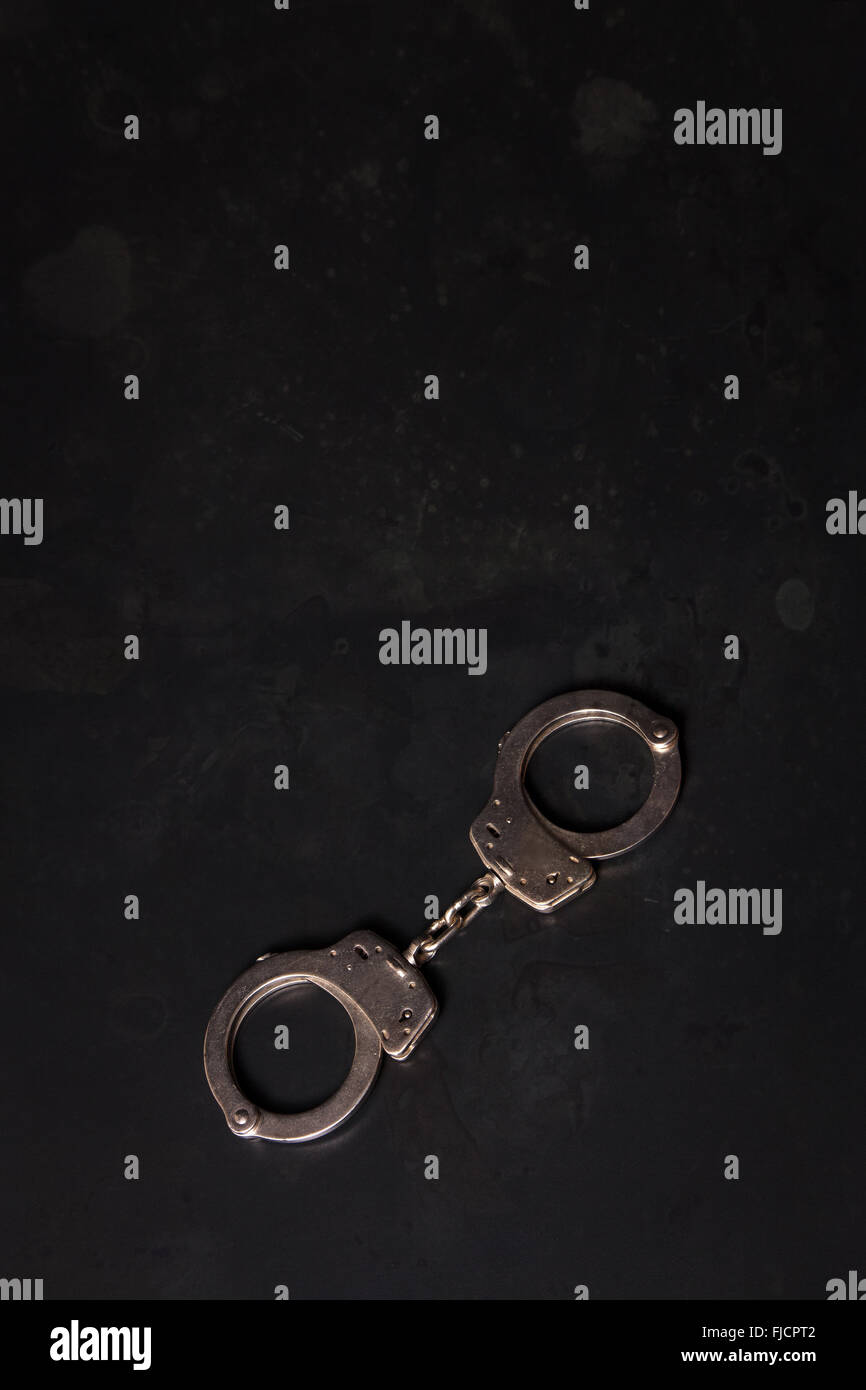 Handcuffs on a black background Stock Photo - Alamy