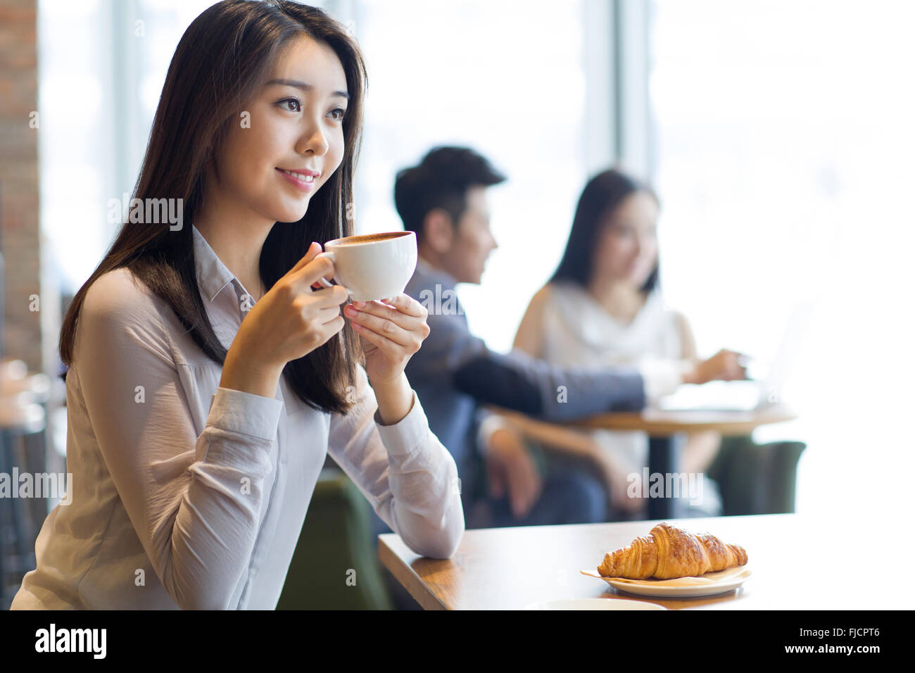 Young Chinese woman drinking coffee in café Stock Photo - Alamy