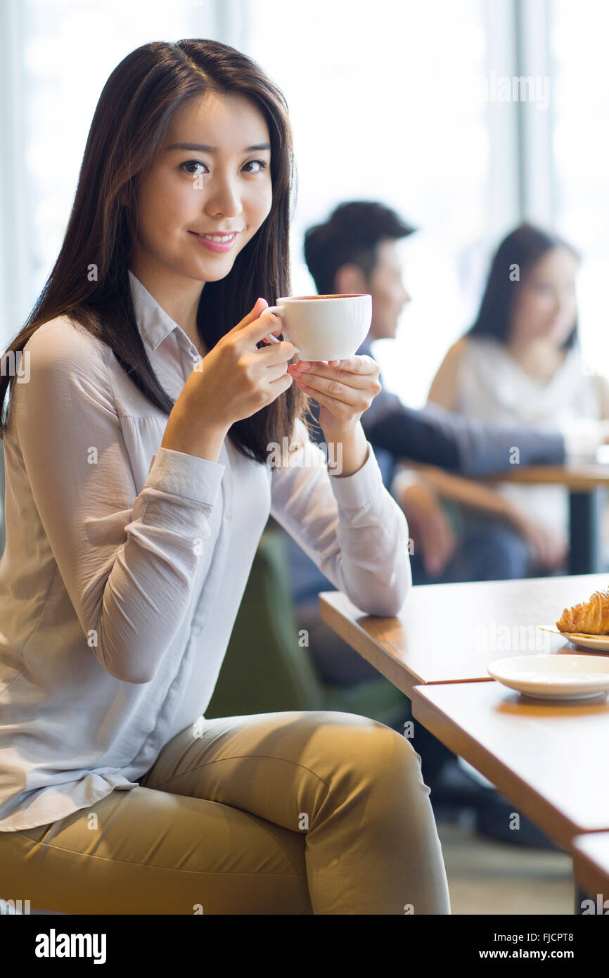 Young Chinese woman drinking coffee in café Stock Photo - Alamy