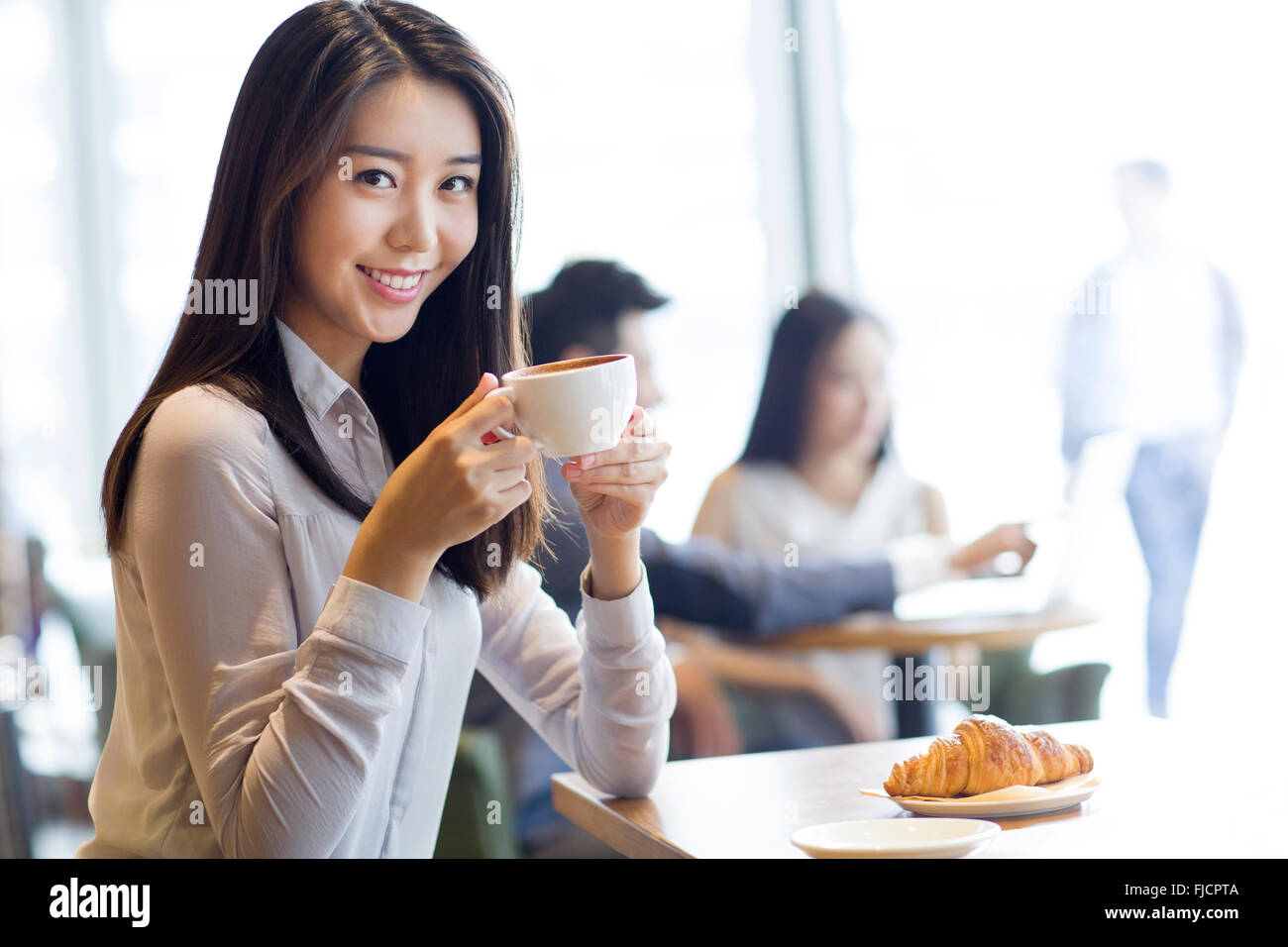 Young Chinese woman drinking coffee in café Stock Photo - Alamy