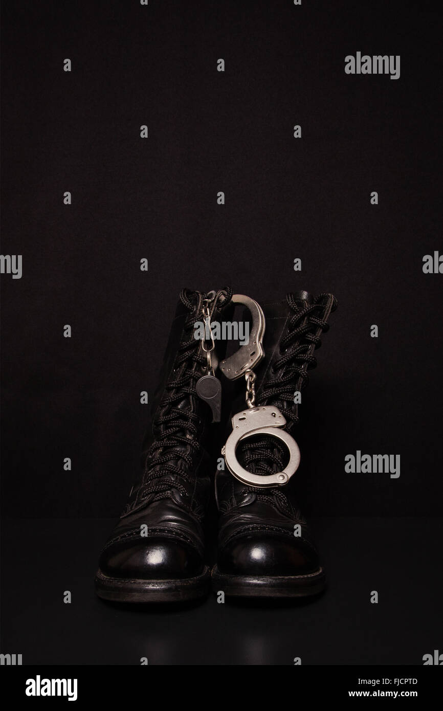 Black combat boots with handcuffs and a whistle for a police officer's ...