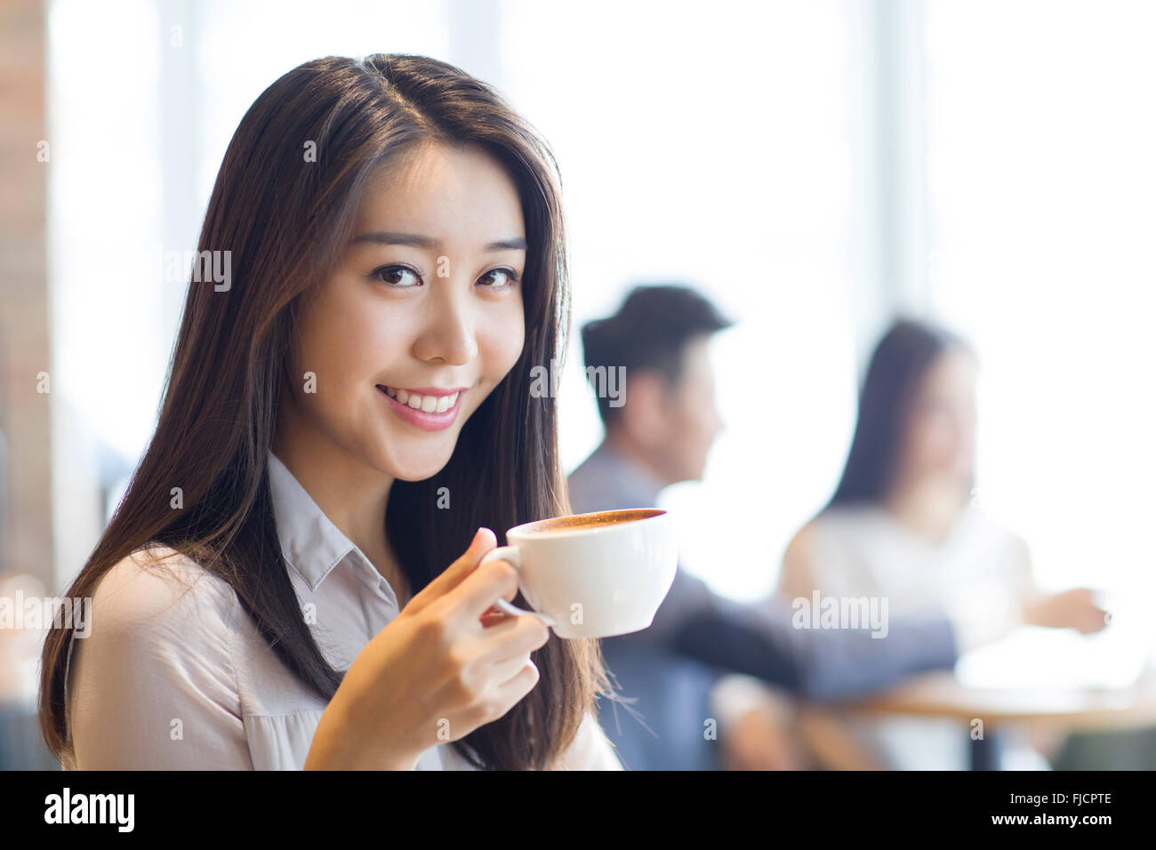 Young Chinese woman drinking coffee in café Stock Photo - Alamy