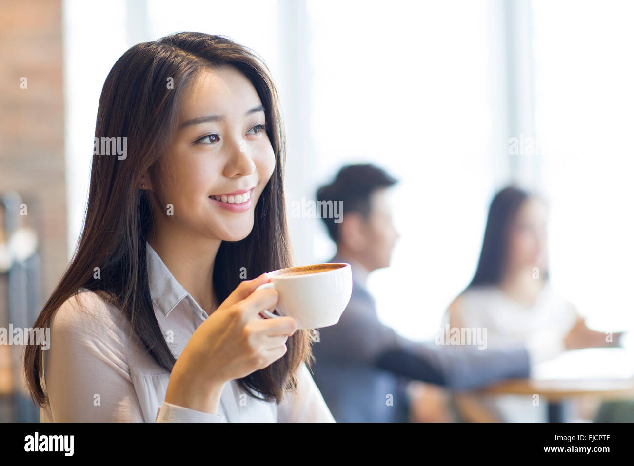 Young Chinese woman drinking coffee in café Stock Photo - Alamy