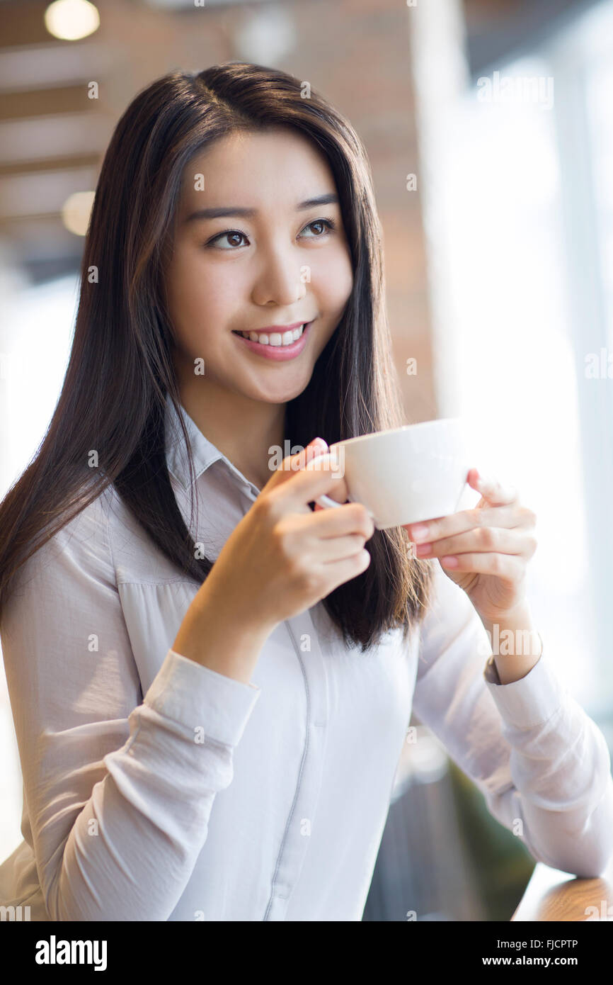 Young Chinese woman drinking coffee in café Stock Photo - Alamy
