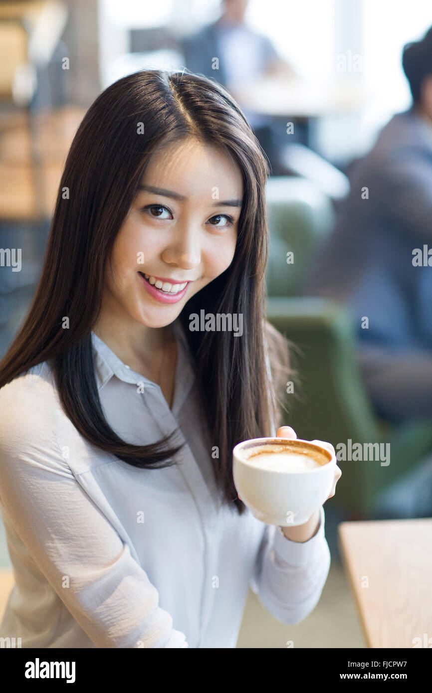 Young Chinese woman drinking coffee in café Stock Photo - Alamy