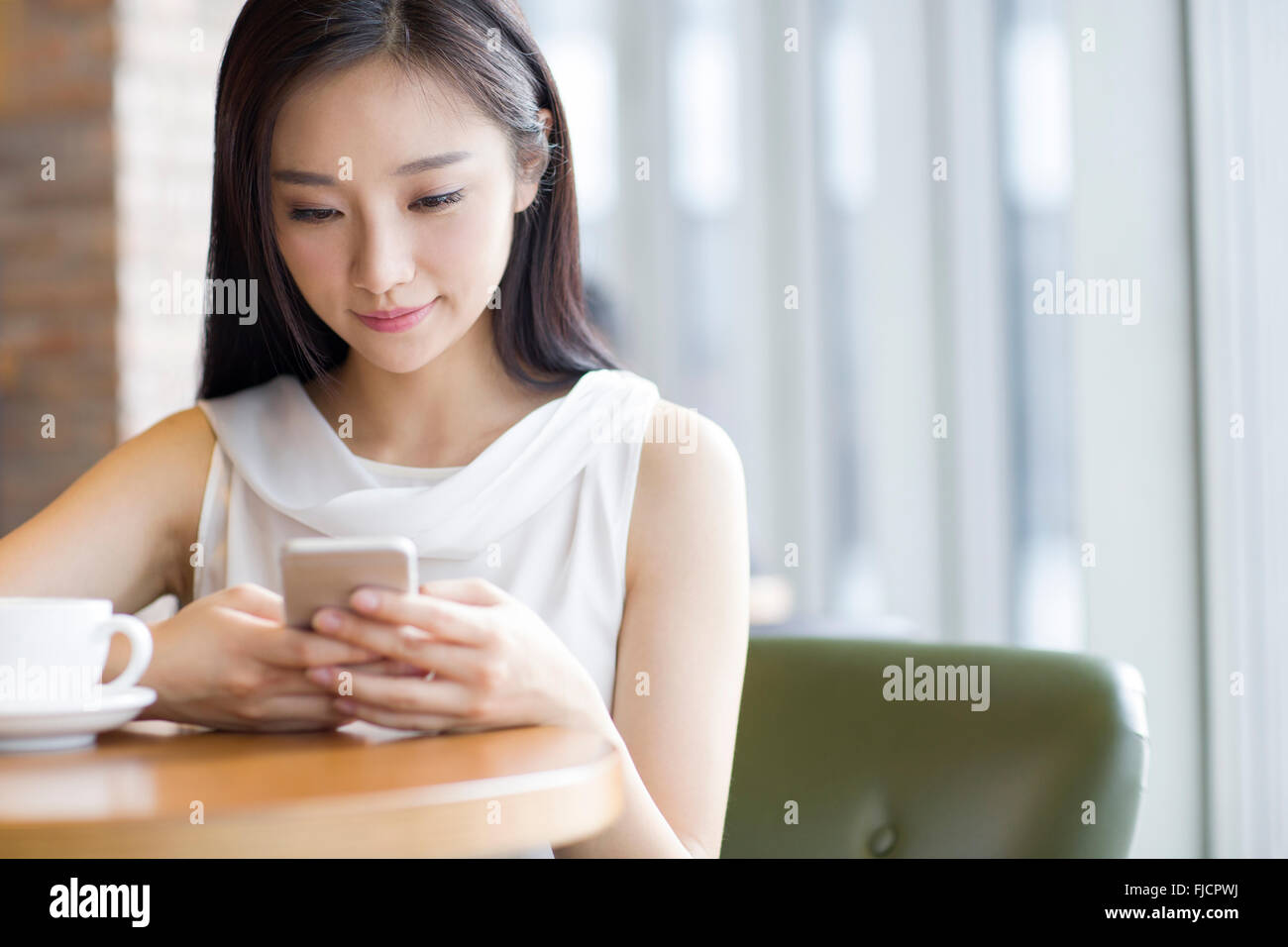 Young Chinese woman using smart phone in café Stock Photo - Alamy