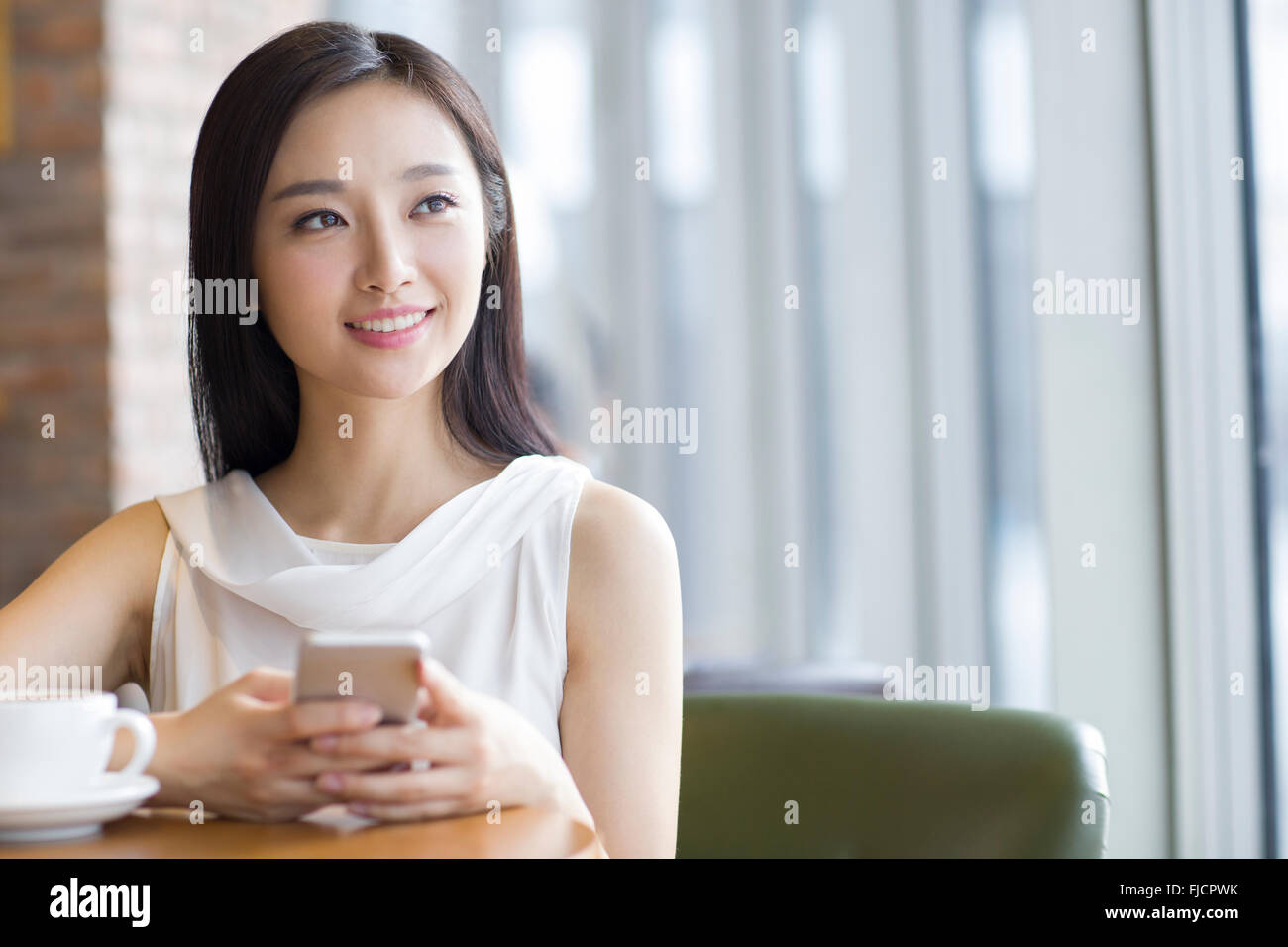 Young Chinese woman using smart phone in café Stock Photo - Alamy