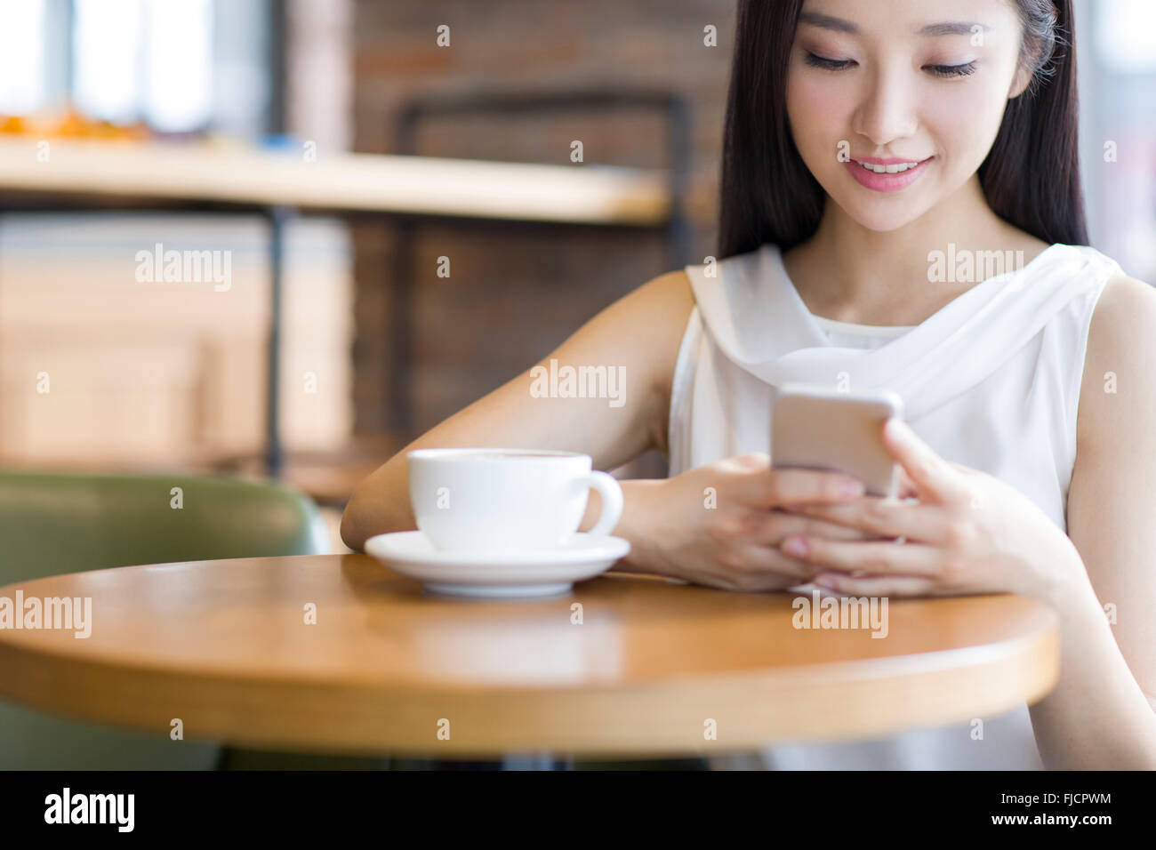 Young Chinese woman using smart phone in café Stock Photo - Alamy