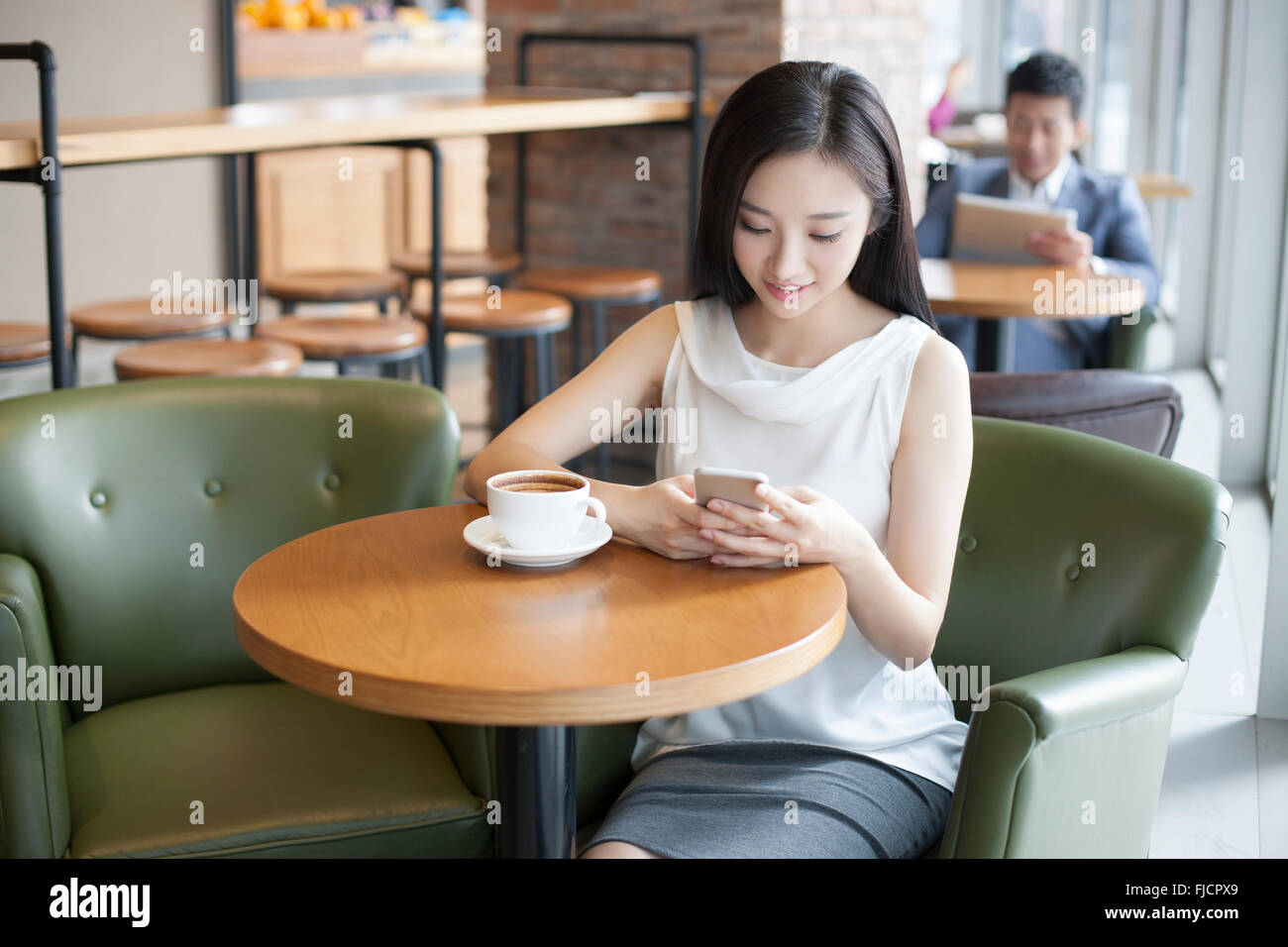 Young Chinese woman using smart phone in café Stock Photo - Alamy