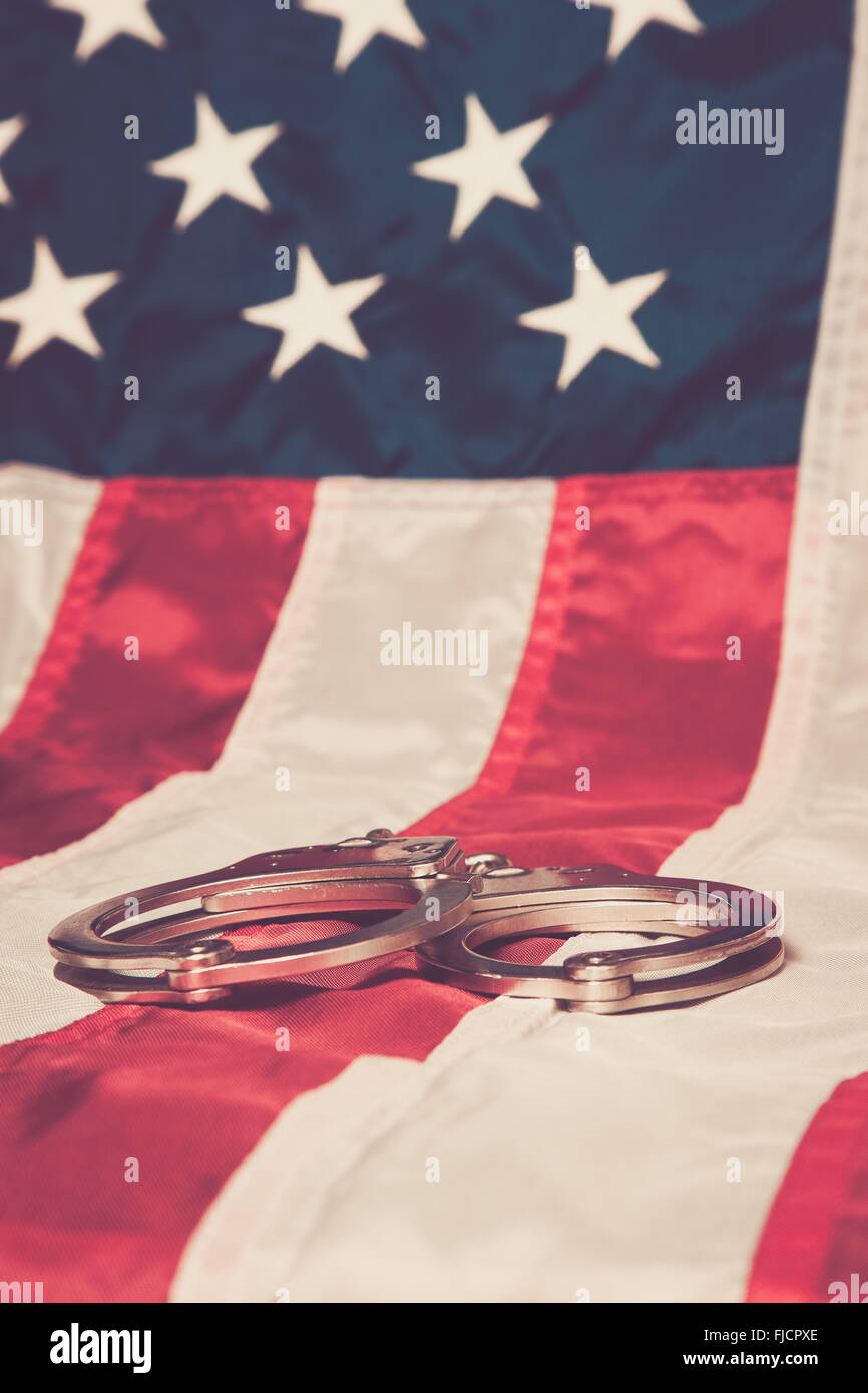 Handcuffs with an American Flag background Stock Photo - Alamy