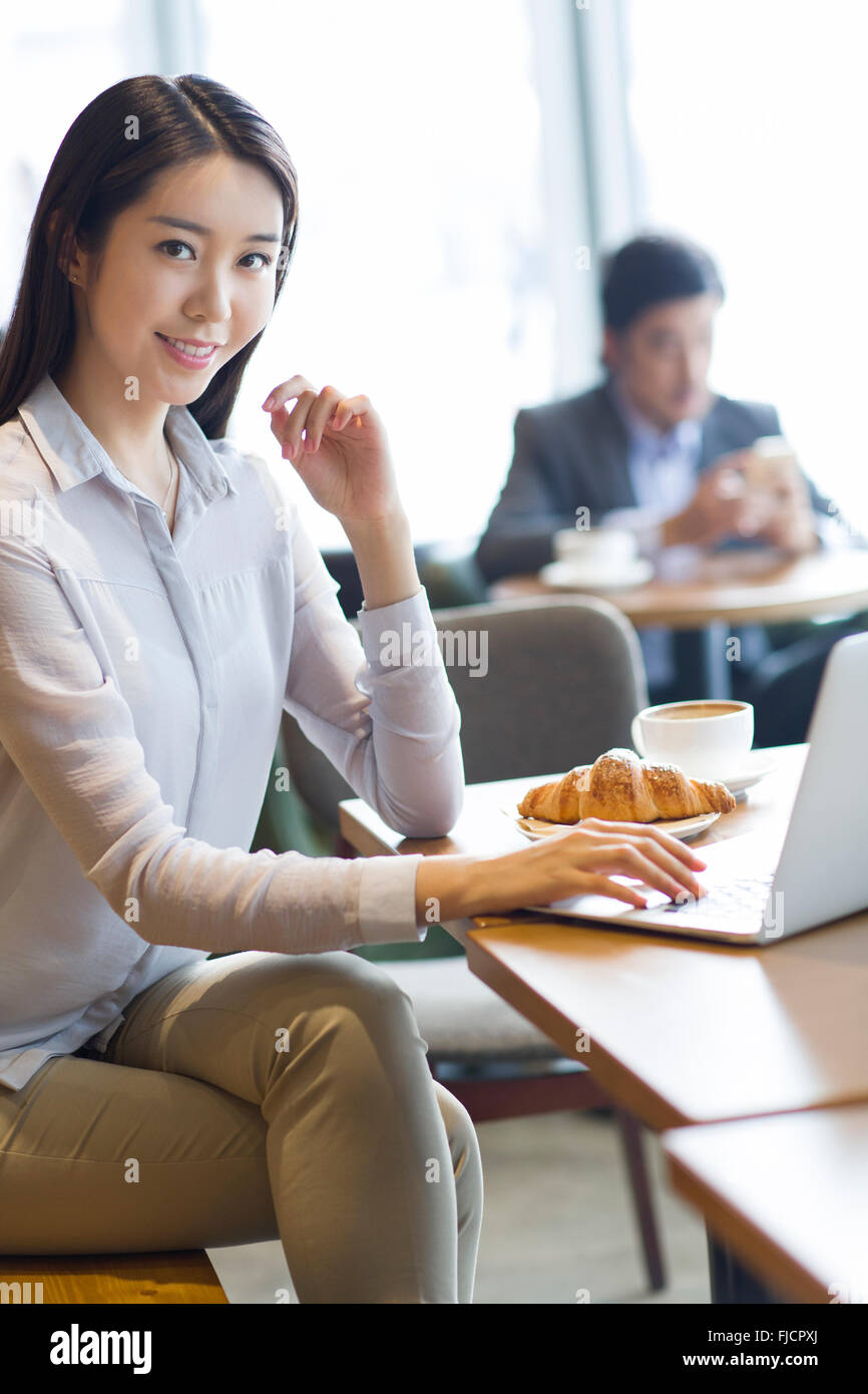Young Chinese woman working with laptop in café Stock Photo - Alamy