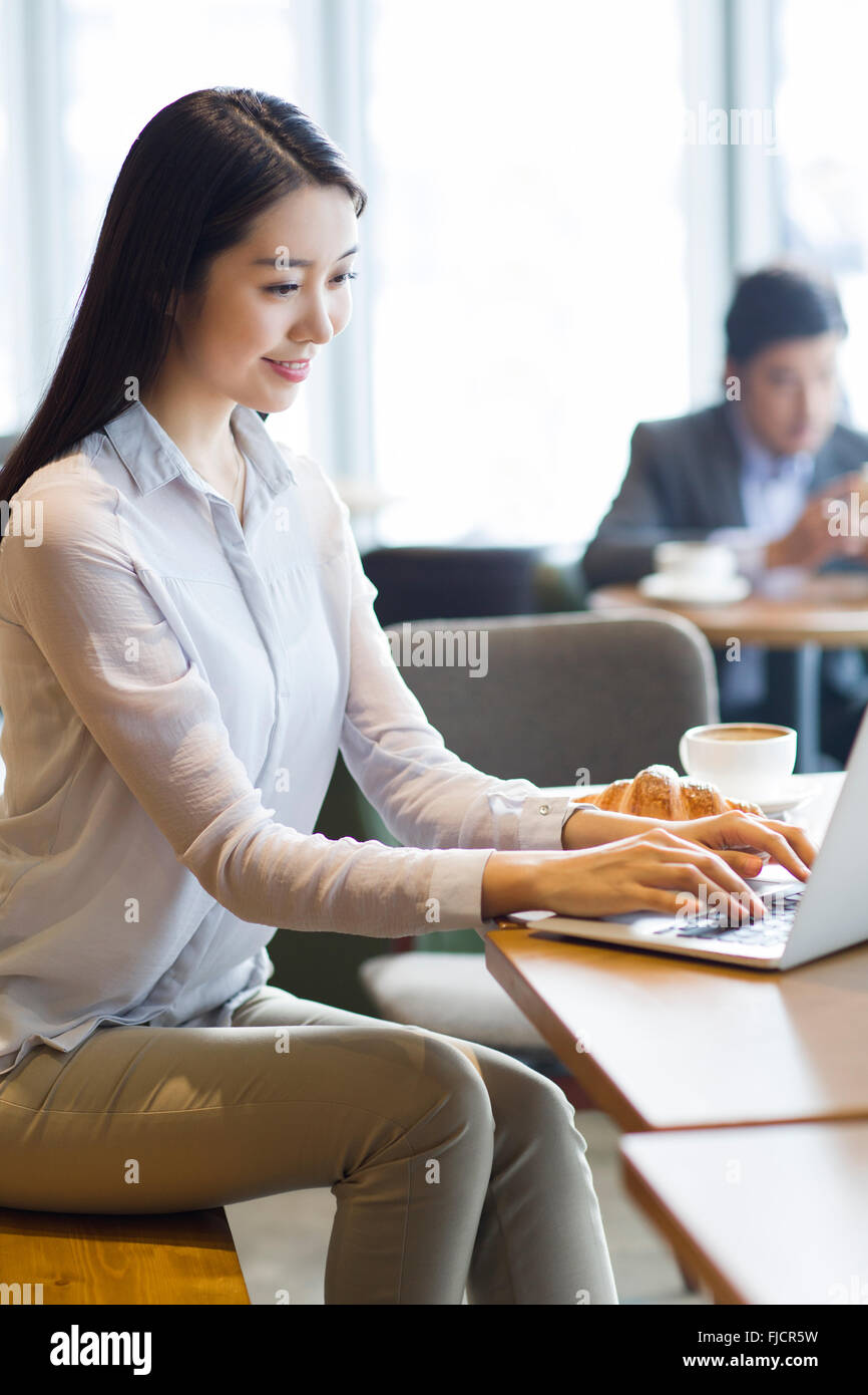 Young Chinese woman working with laptop in café Stock Photo - Alamy