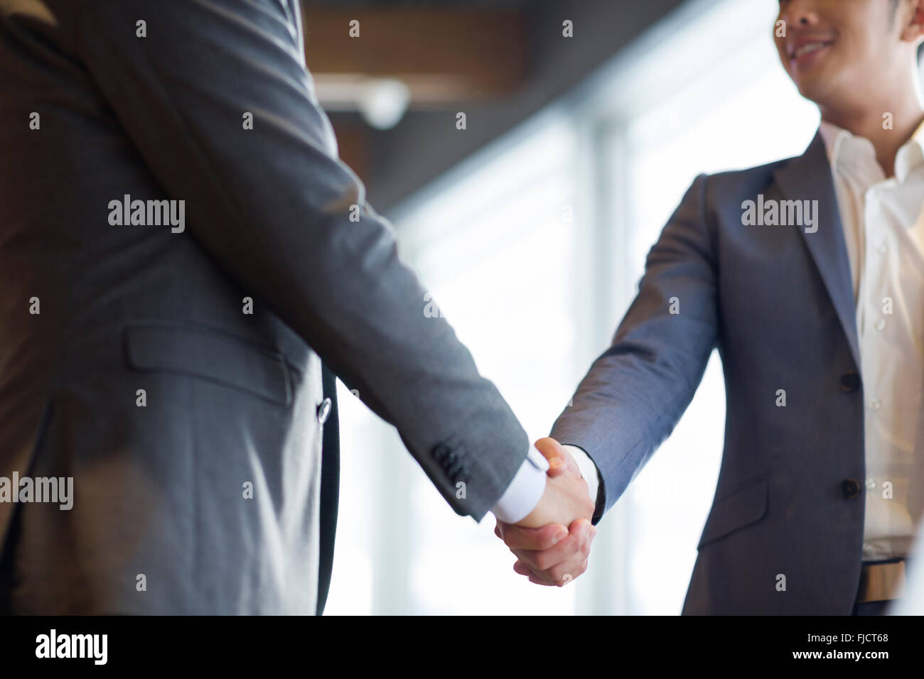 Chinese businessmen shaking hands Stock Photo - Alamy