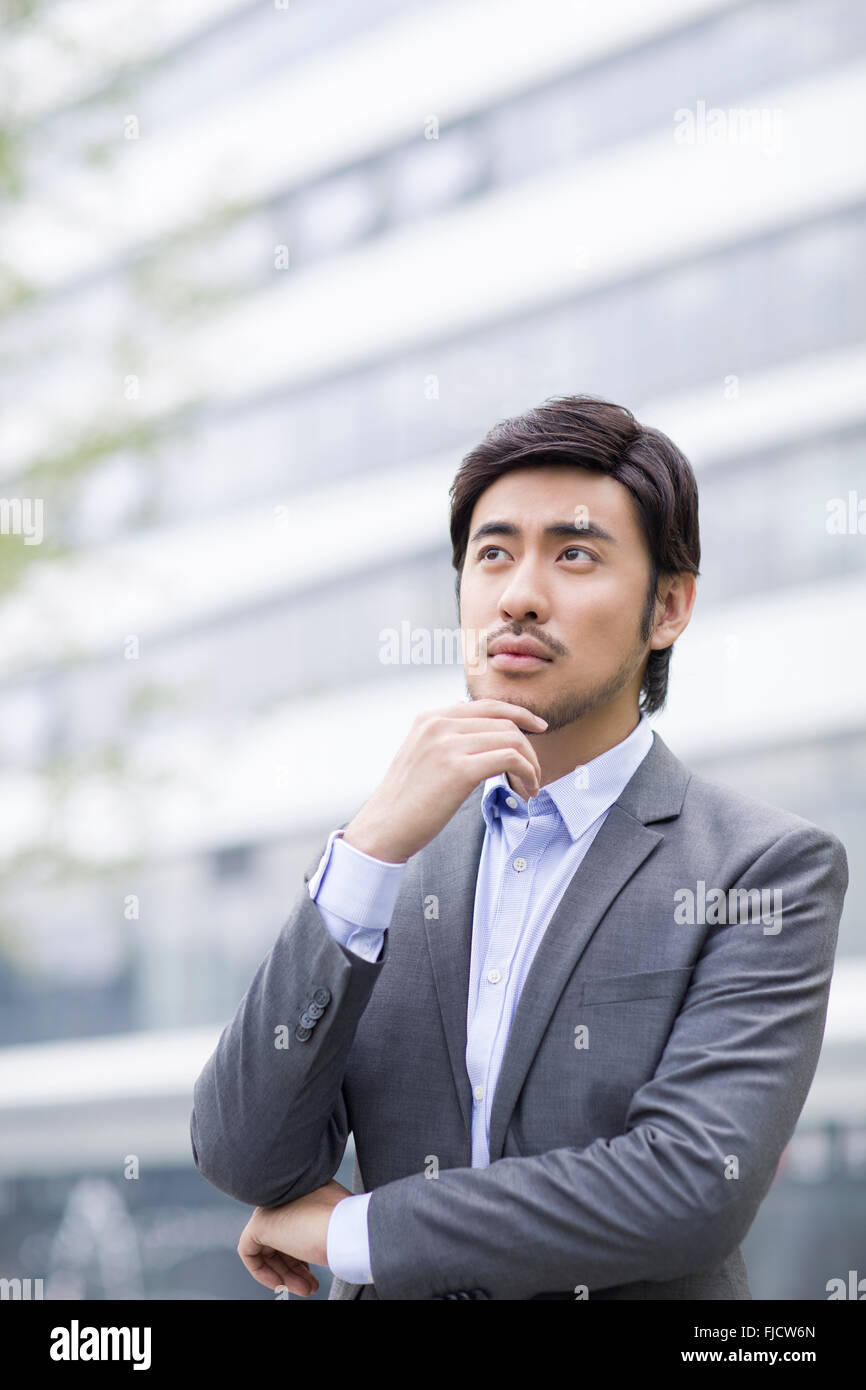 Chinese businessman thinking Stock Photo - Alamy