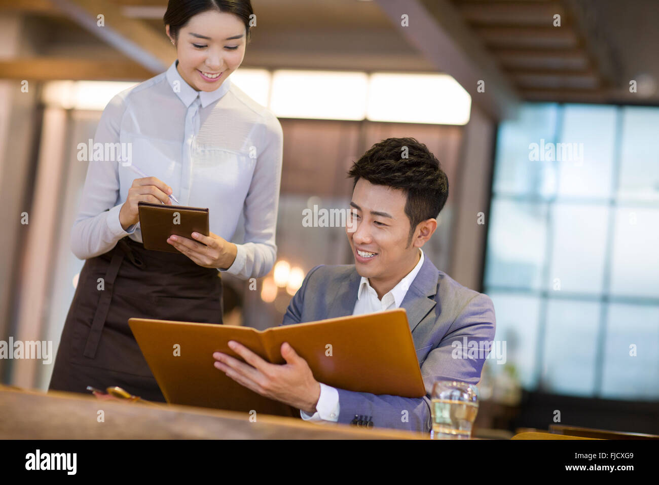 Young Chinese man ordering in restaurant Stock Photo - Alamy