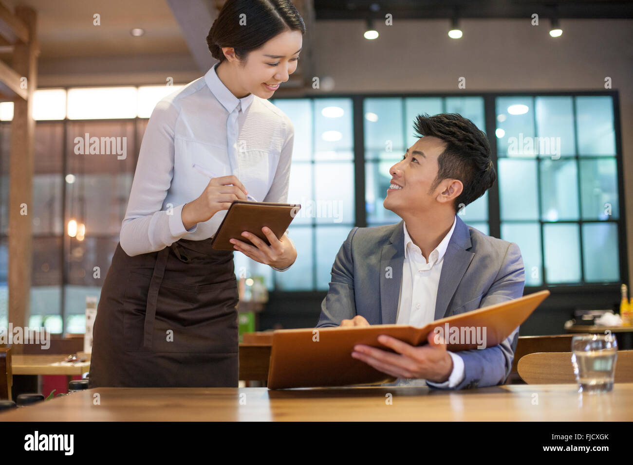 Young Chinese man ordering in restaurant Stock Photo - Alamy