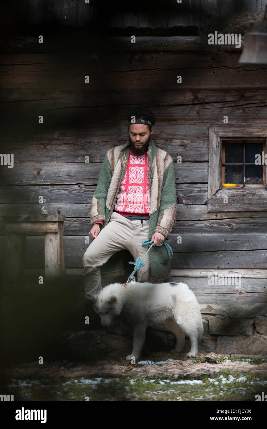 handsome young hipster man standing together with white husky dog in ...
