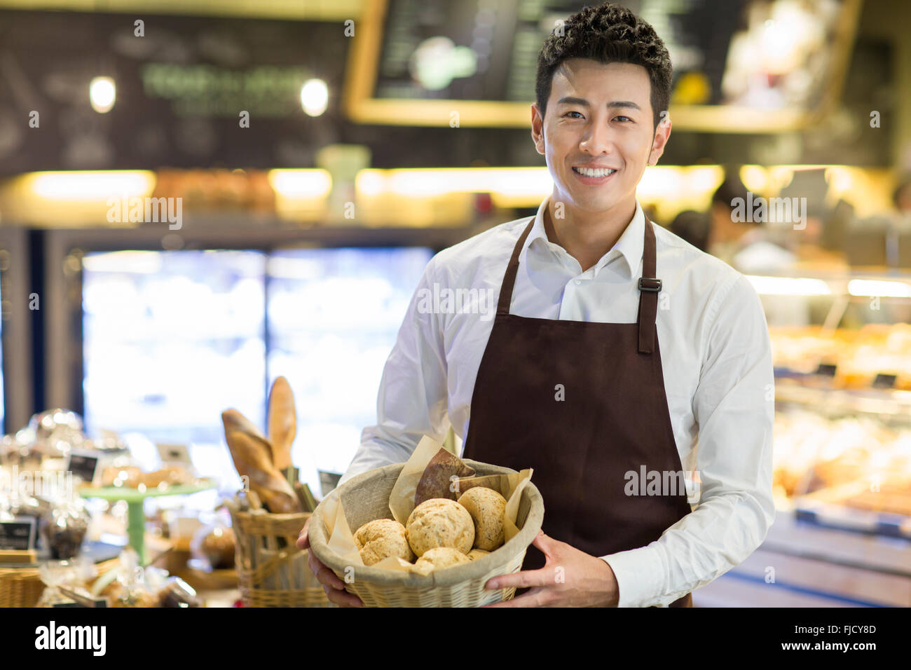 Young Chinese man working in bakery Stock Photo - Alamy