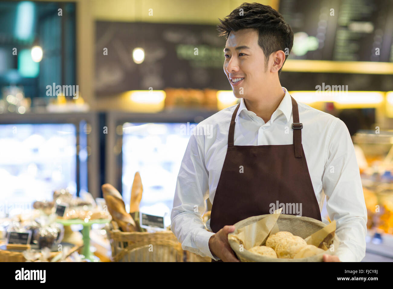 Young Chinese man working in bakery Stock Photo - Alamy