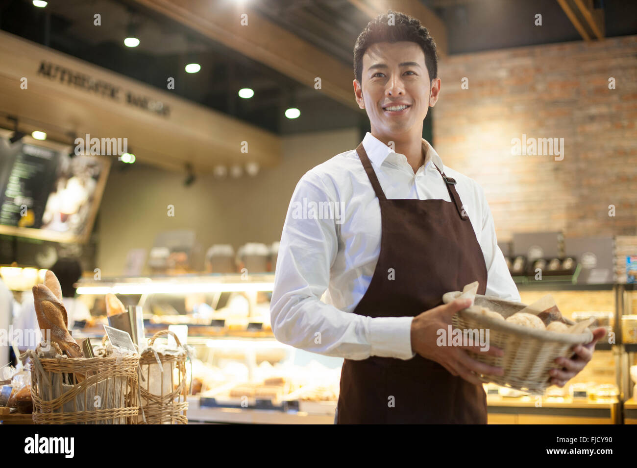 Young Chinese man working in bakery Stock Photo - Alamy