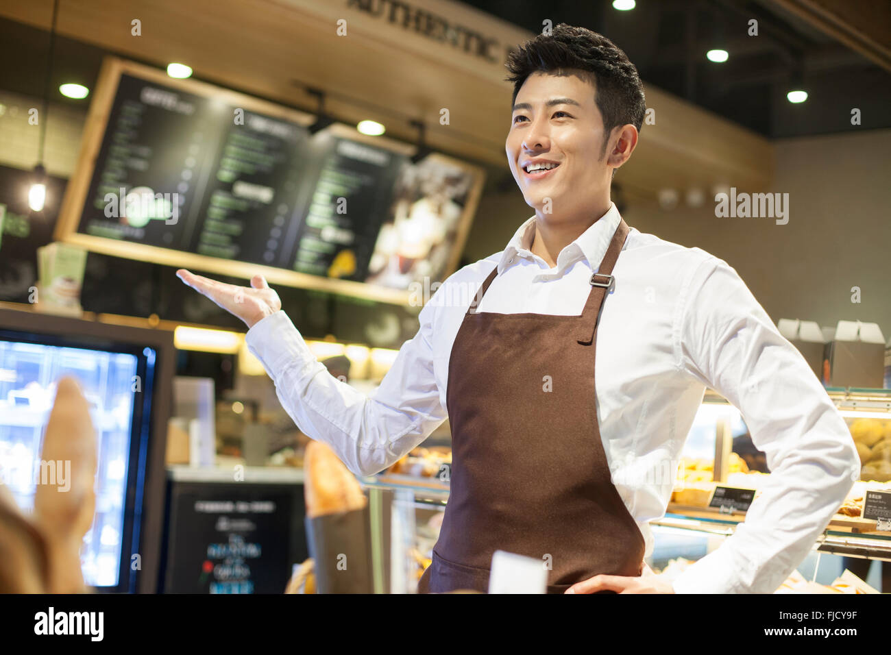 Young Chinese man working in bakery Stock Photo - Alamy