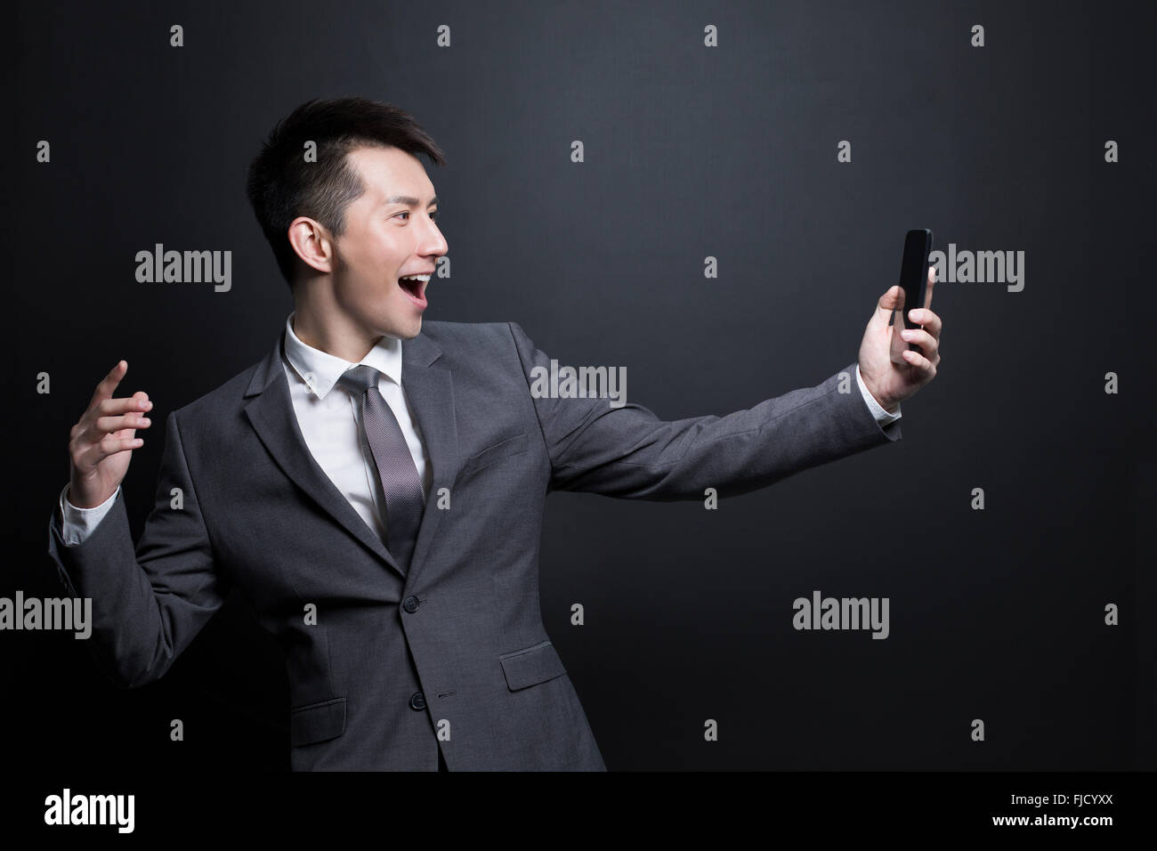 Excited businessman holding smart hi-res stock photography and images ...