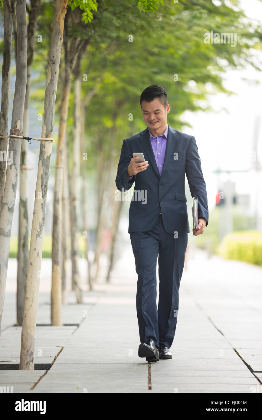 A happy Chinese business man using his smart phone Stock Photo - Alamy