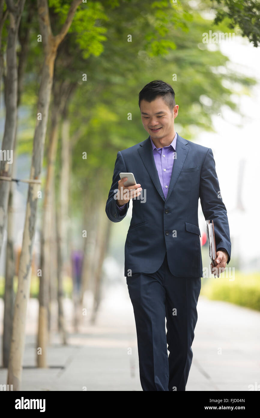A happy Chinese business man using his smart phone Stock Photo - Alamy