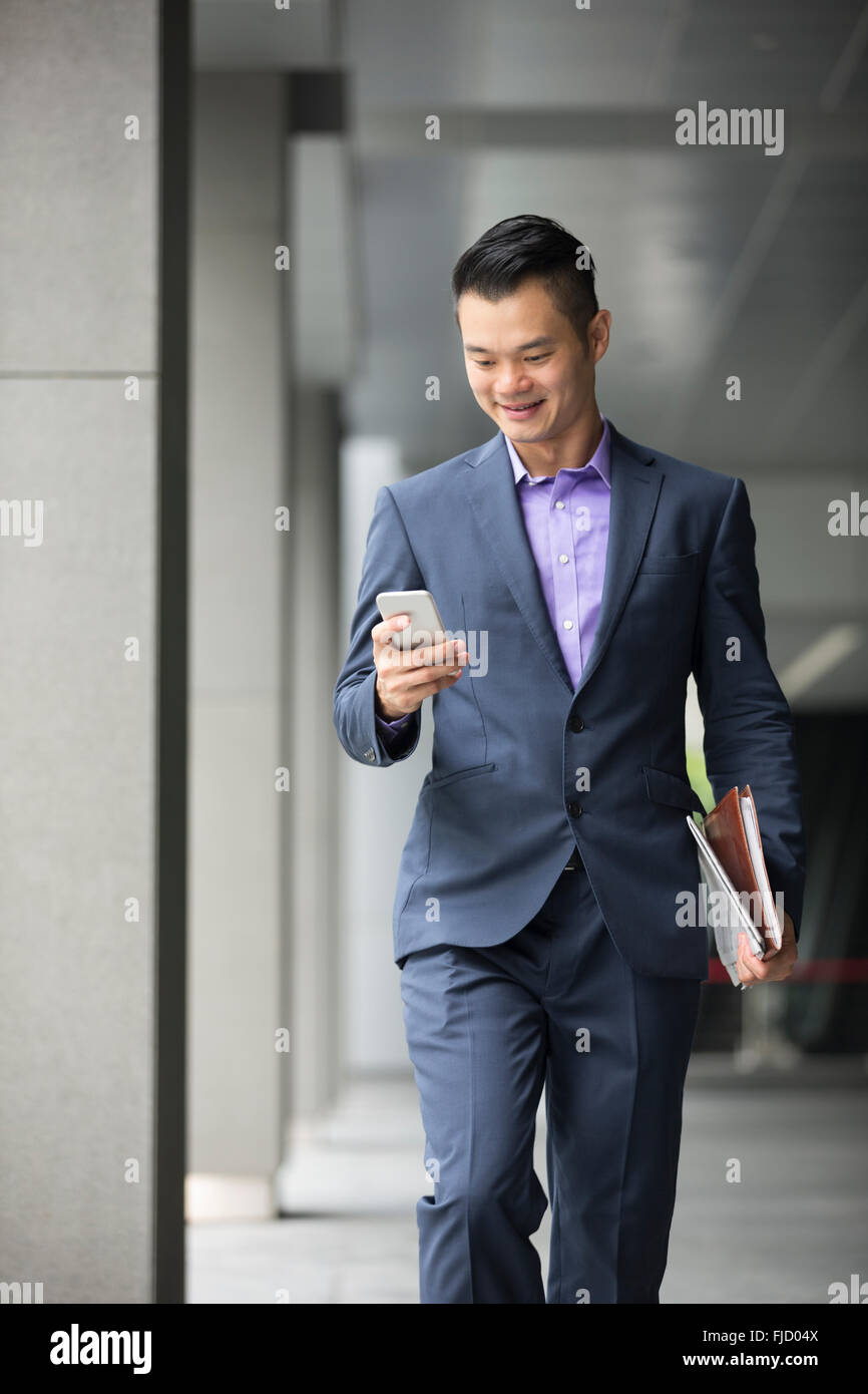 A happy Chinese business man using his smart phone Stock Photo - Alamy