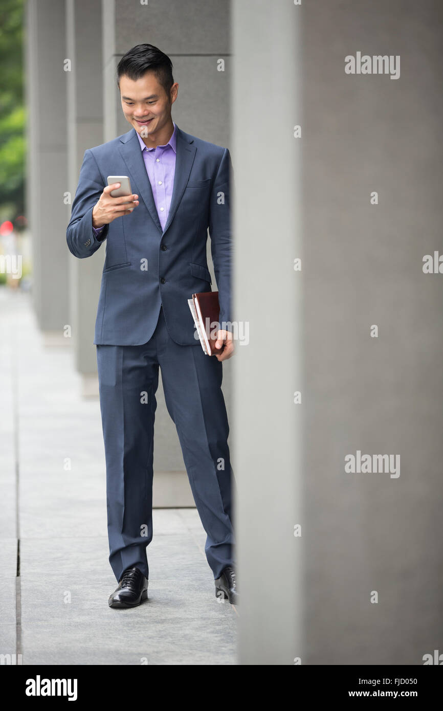 A happy Chinese business man using his smart phone Stock Photo - Alamy