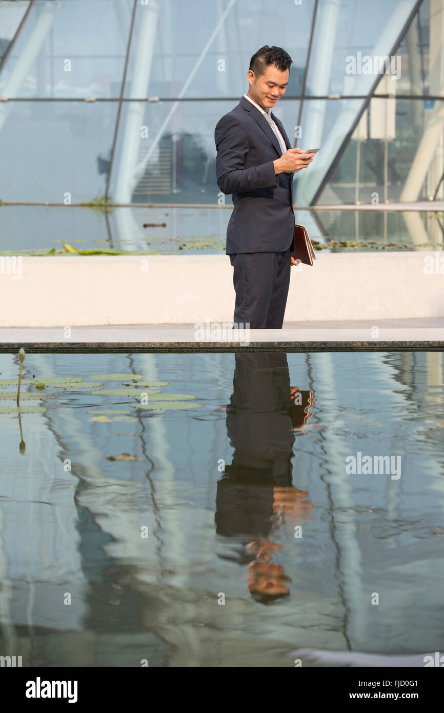 A happy Chinese business man using his smart phone Stock Photo - Alamy