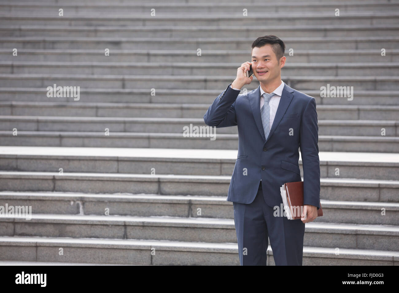 A happy Chinese business man using his smart phone Stock Photo - Alamy