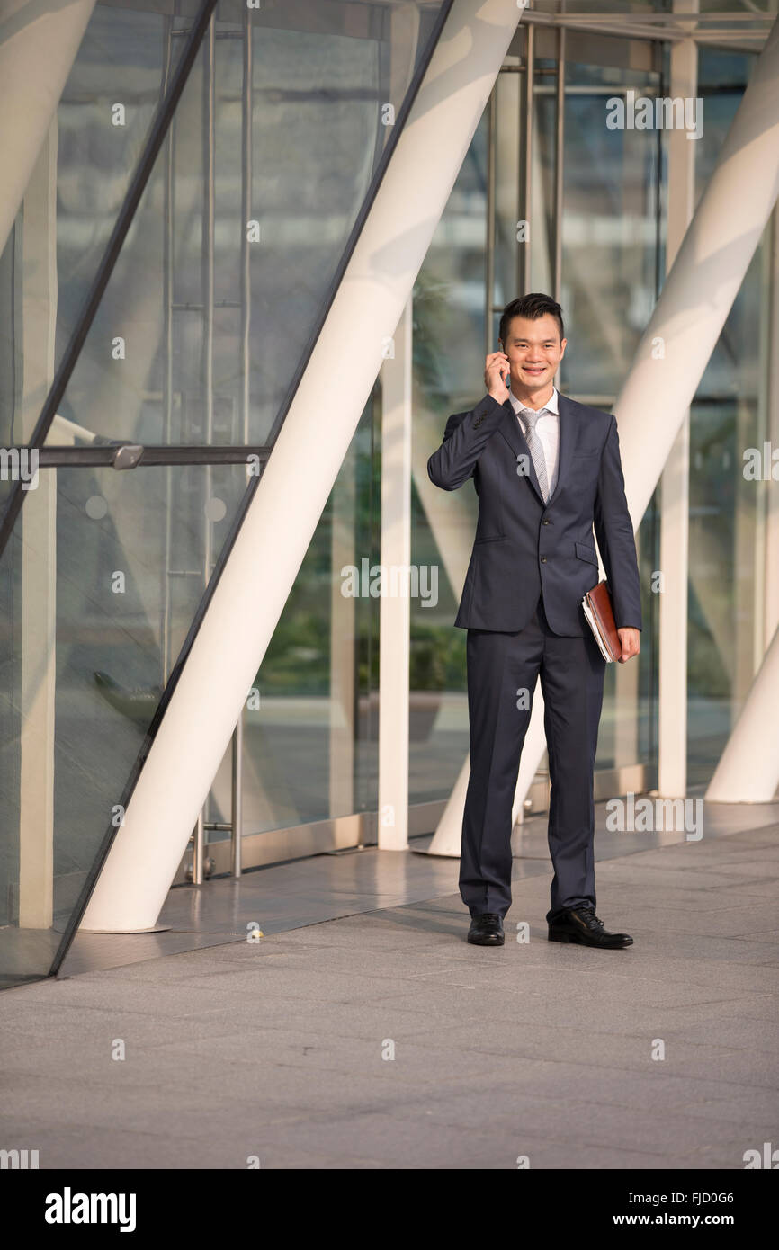 A happy Chinese business man using his smart phone Stock Photo - Alamy