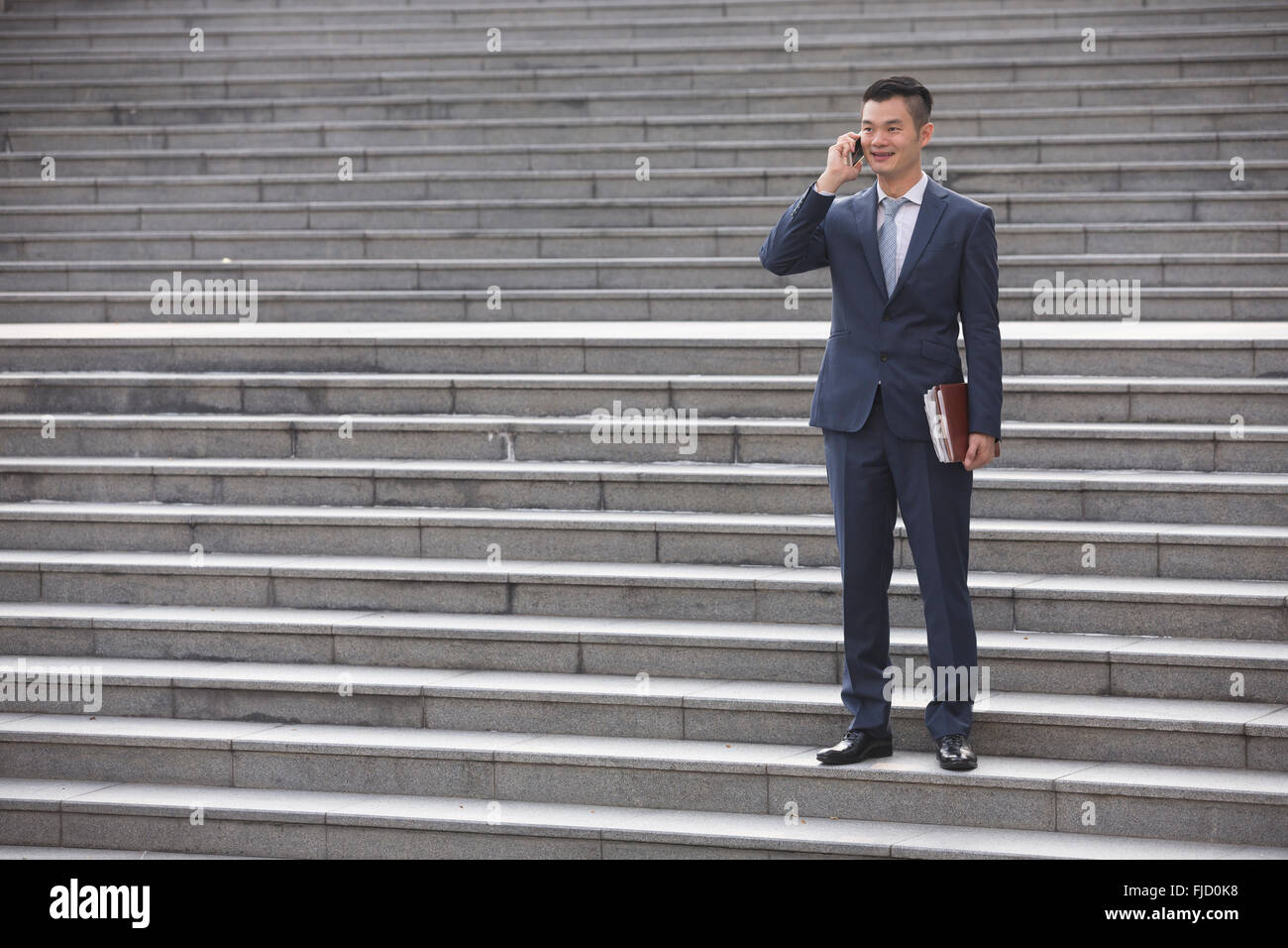 A happy Chinese business man using his smart phone Stock Photo - Alamy