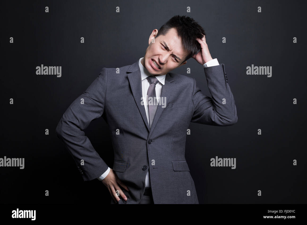 Chinese businessman scratching head Stock Photo - Alamy