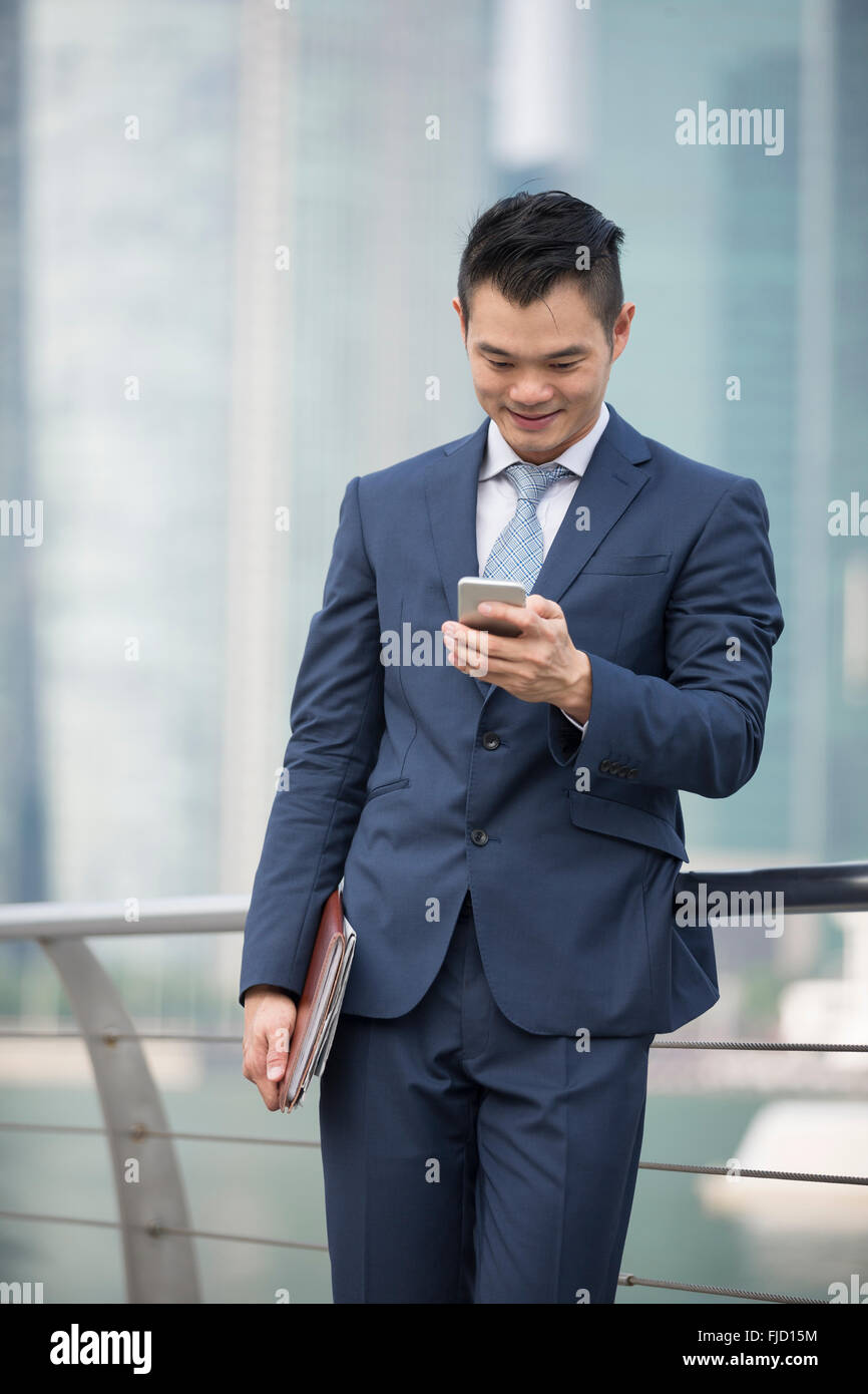 A happy Chinese business man using his smart phone Stock Photo - Alamy
