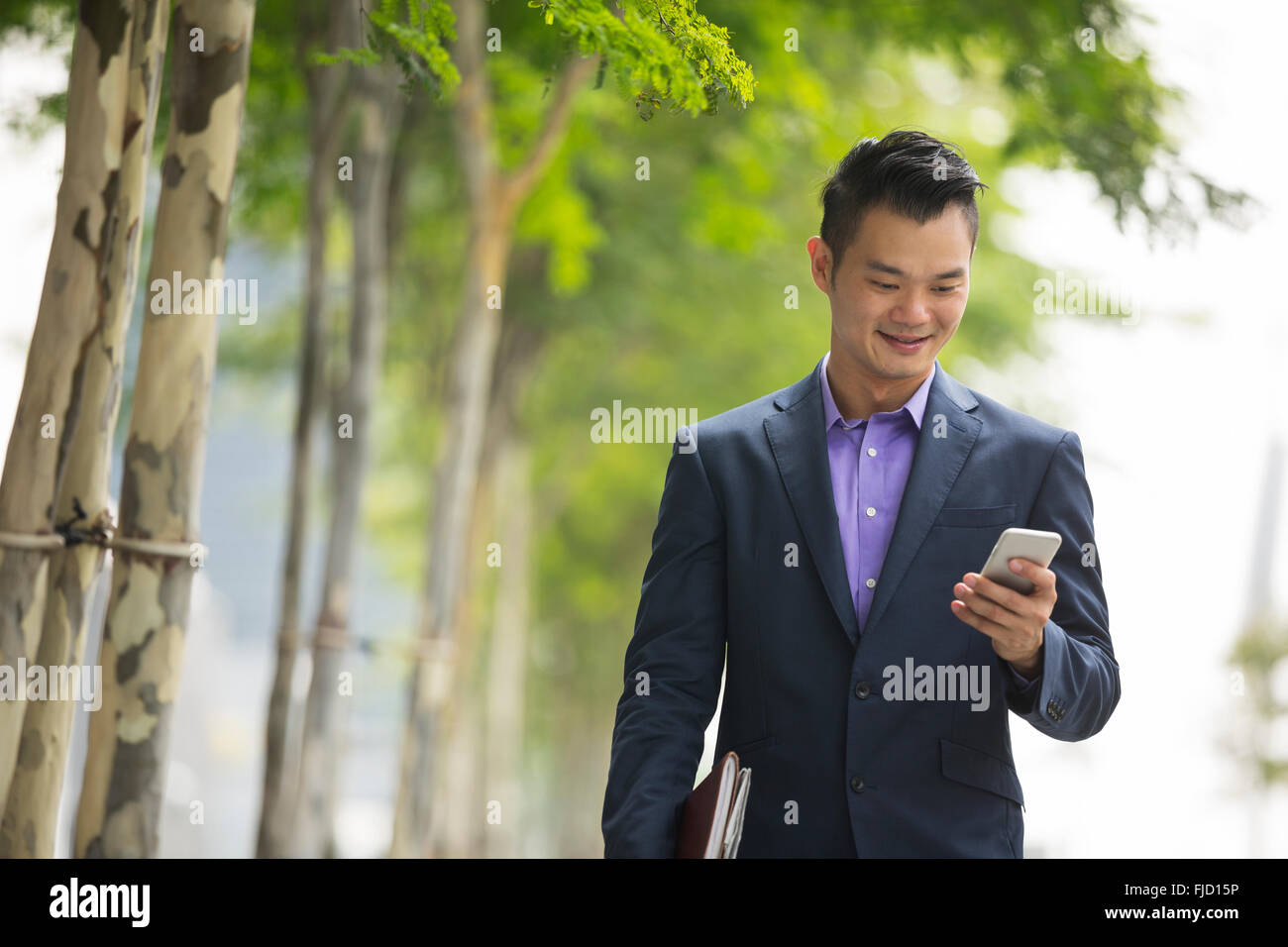 A happy Chinese business man using his smart phone Stock Photo - Alamy