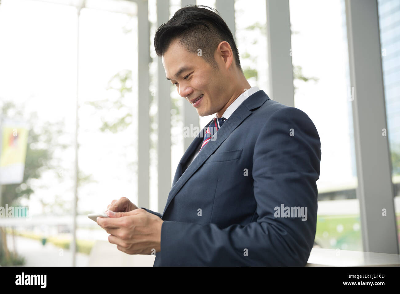 A happy Chinese business man using his smart phone Stock Photo - Alamy