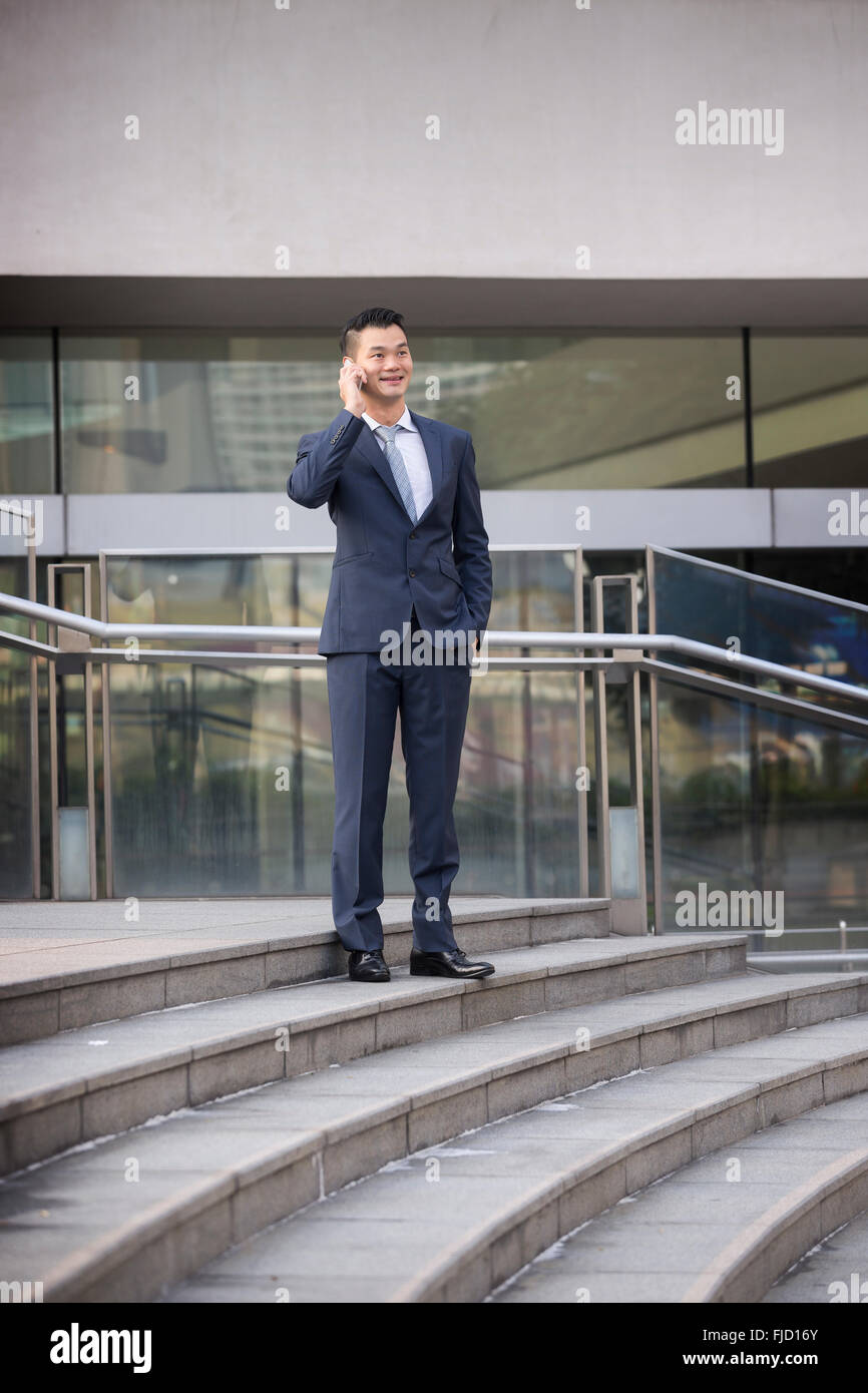 A happy Chinese business man using his smart phone Stock Photo - Alamy