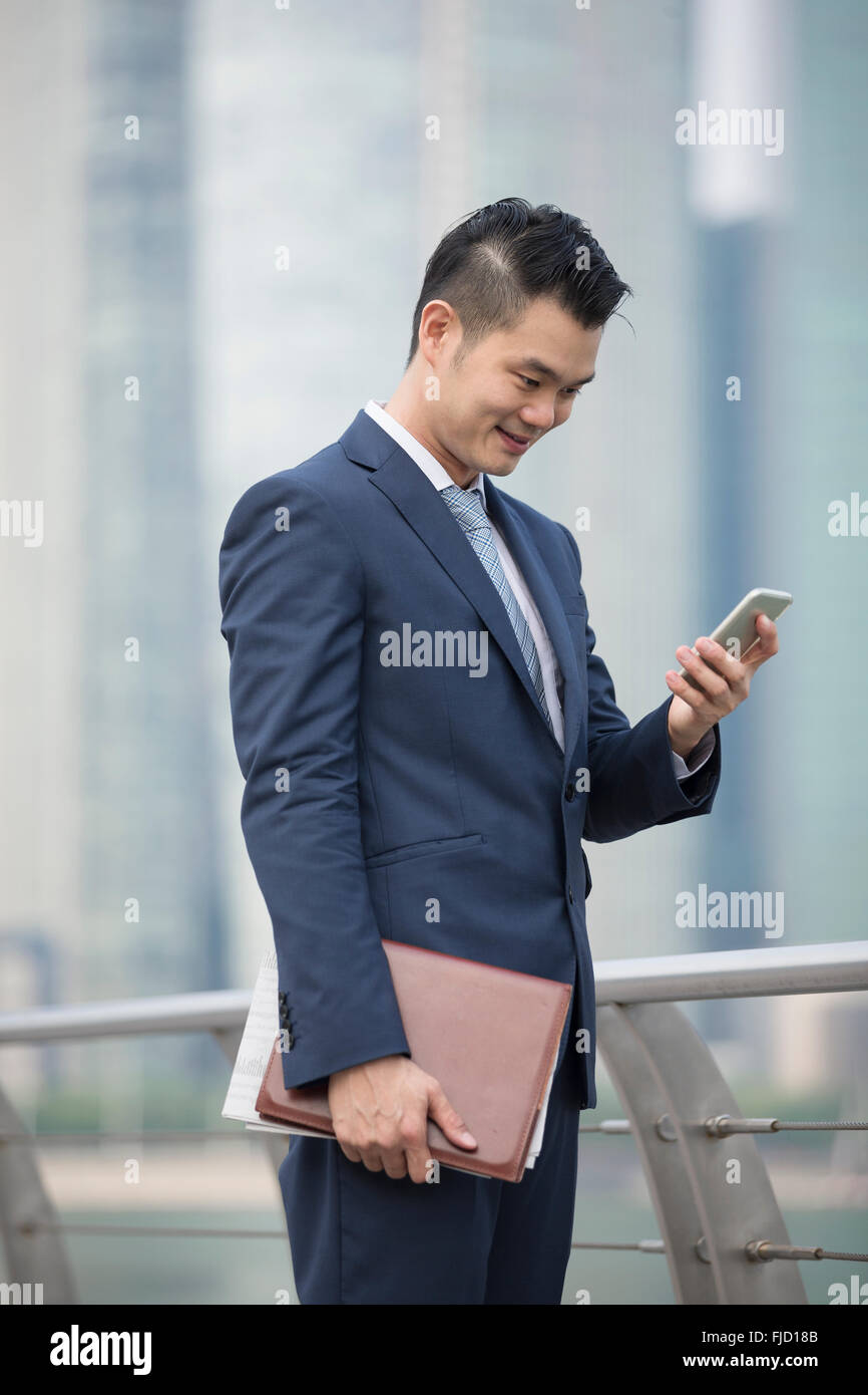 A happy Chinese business man using his smart phone Stock Photo - Alamy