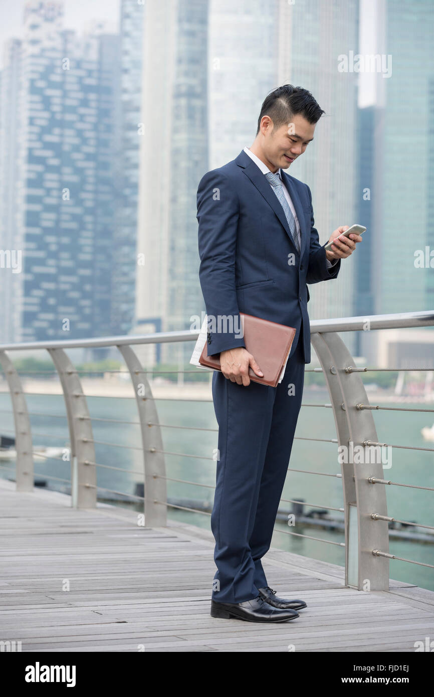 A happy Chinese business man using his smart phone Stock Photo - Alamy