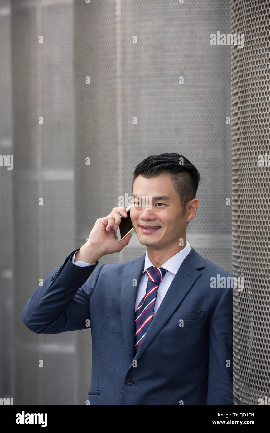 A happy Chinese business man using his smart phone Stock Photo - Alamy