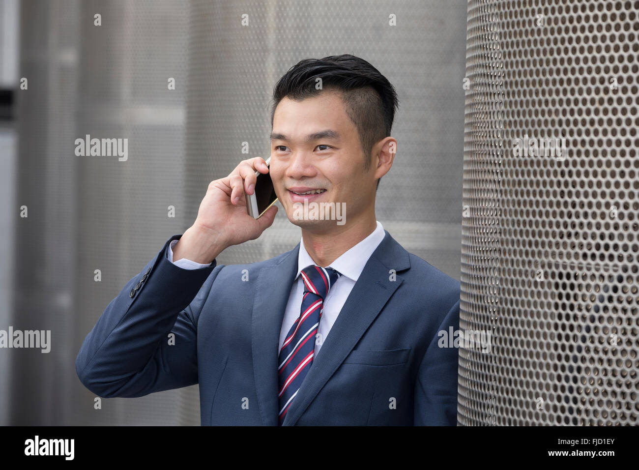 A portrait of a happy Chinese business man using his smart phone Stock ...