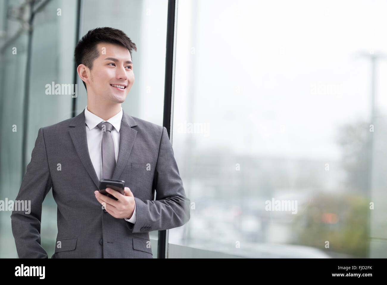 Chinese businessman holding a smart phone Stock Photo - Alamy